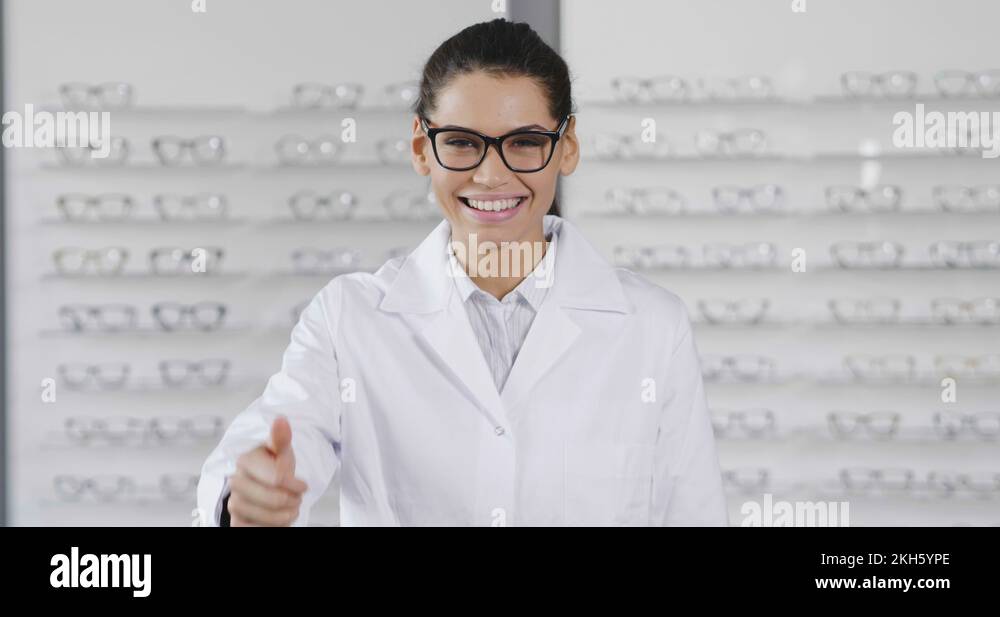 An ophthalmologist is smiling in camera during working in an optical ...