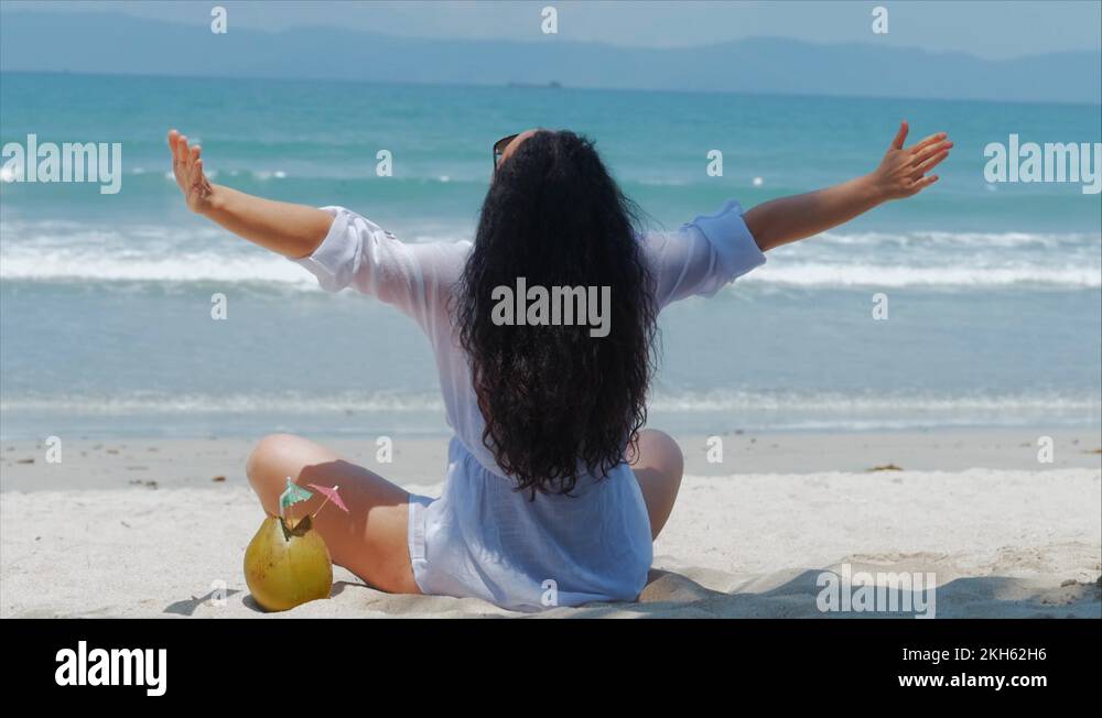 Young woman or a cheerful girl, sunbathing on the beach, enjoying the ...