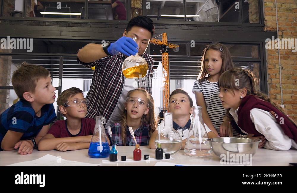 Scientist showing kids how to do chemical reaction experiments in lab ...