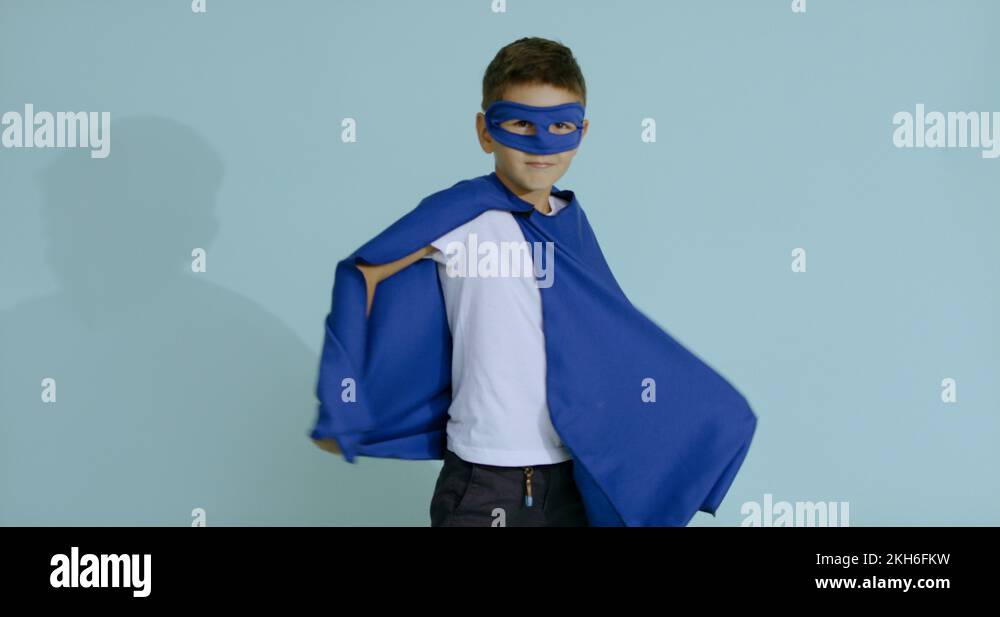 Caucasian kid boy wearing blue cape and mask, pretending to be a ...