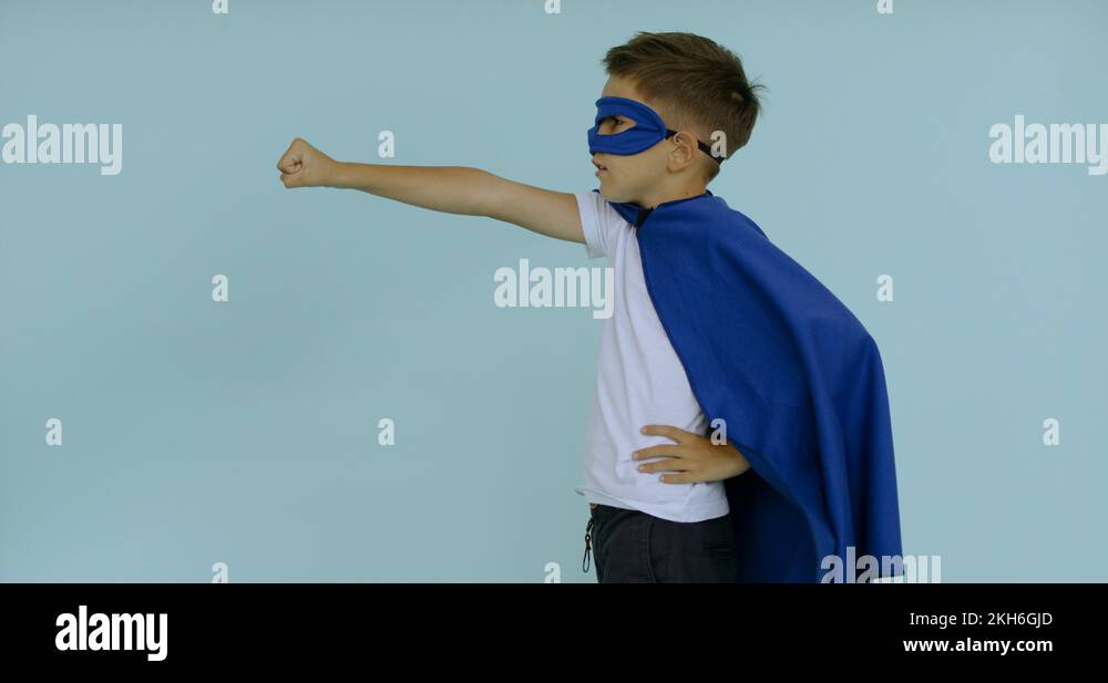 Caucasian kid boy wearing blue cape and mask, pretending to be a ...