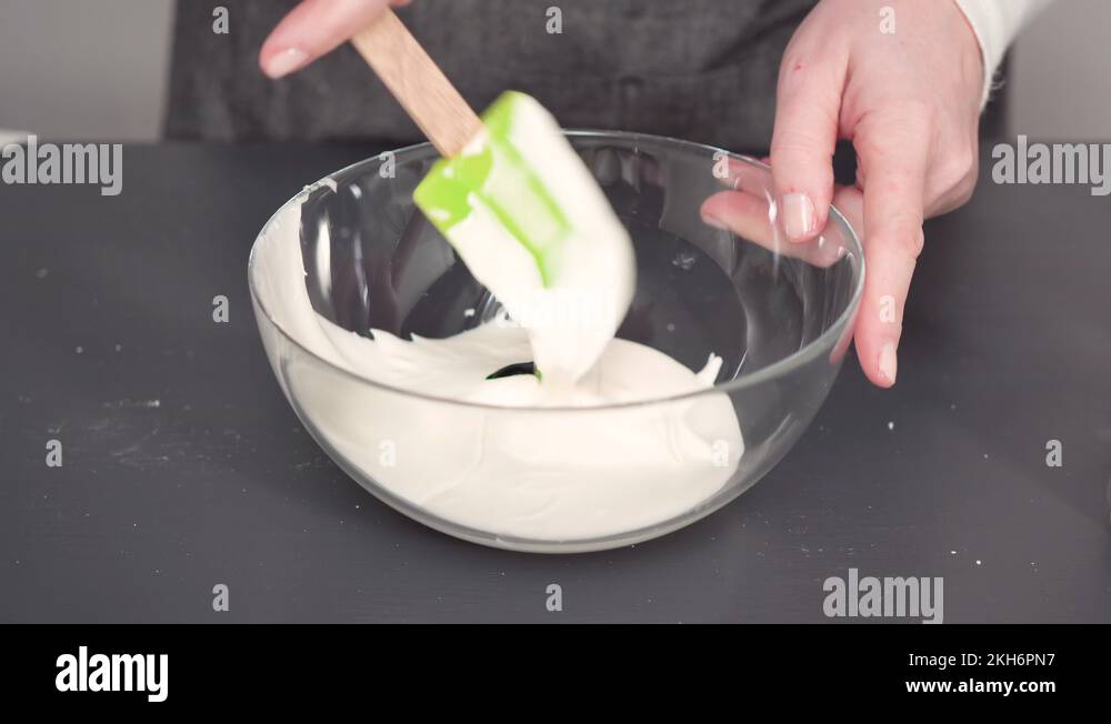Mixing in food coloring into the royal icing to decorate sugar cookies ...