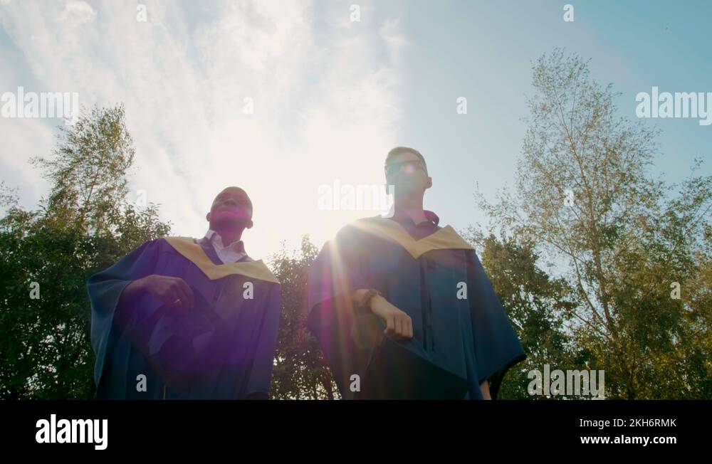 Two Happy Graduate Students in Gowns Throw Up Caps after Graduation ...