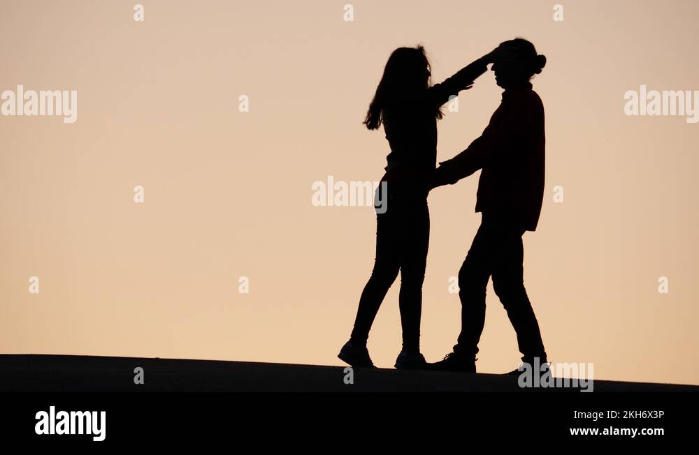 Man hug woman tight and rise up from ground, happy girl wave legs in ...