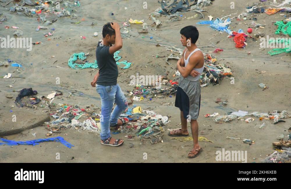 Two poor male friends Indian countryside talking to each other at dirty ...