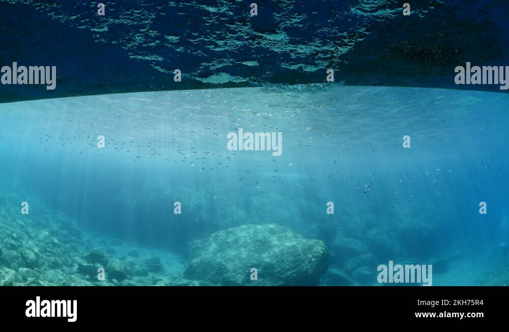 sun beam sun rays sun shine underwater under the boat fish around Stock ...