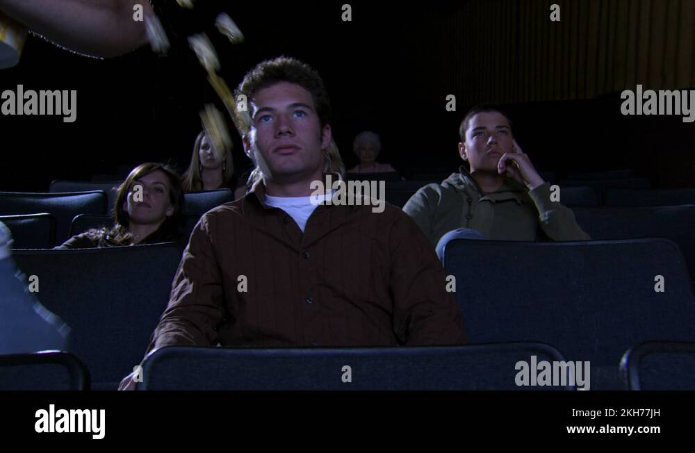 Overweight man with popcorn at movie theatre with young couple Stock ...