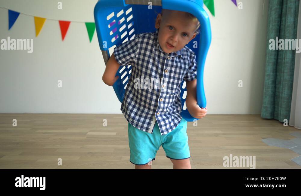 Mad toddler boy with plastic box on head turn actively. Gimbal motion ...