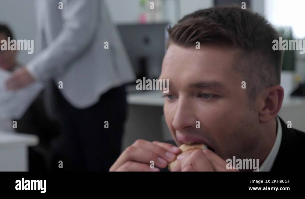 Man eat at the office, lunch, people work behind him Stock Video ...