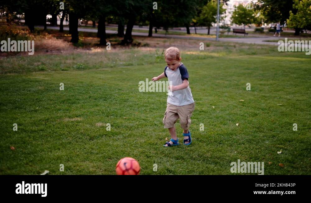 Child boy playing football in park and missed. Kid fail kicking soccer ...
