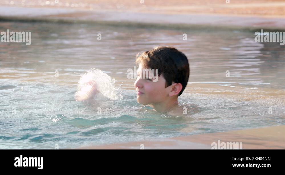 Siblings dispute. Small brothers fighting splashing water inside pool ...