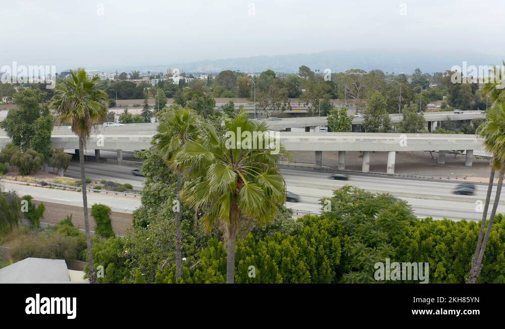 Side view on Los Angeles two-level freeway with fast moving cars. Palm ...