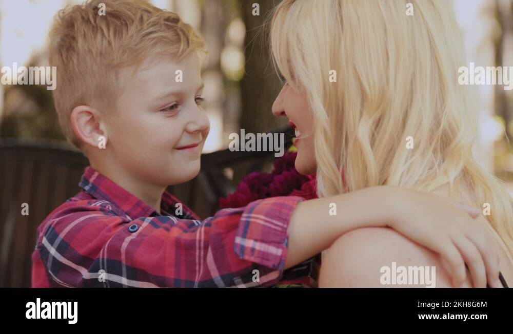 Beautiful little boy gives a bouquet of flowers to his beloved mother ...