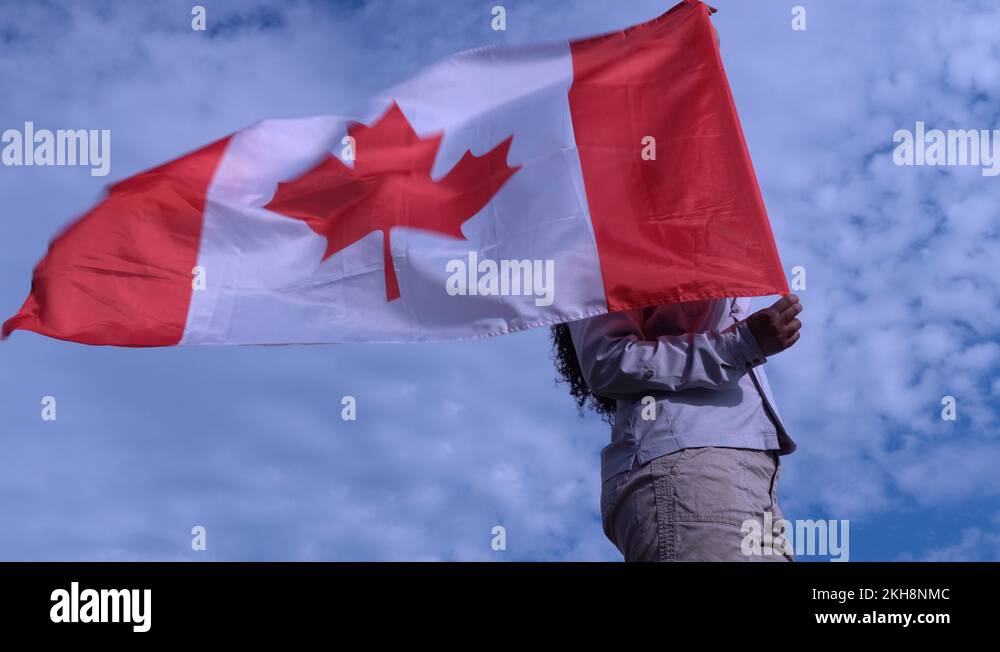 Adult woman standing with pride and Canadian flag waving. Canada symbol ...