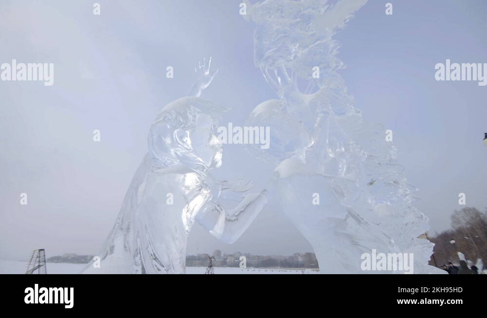 Ice sculpture of children playing with a flying kite with tilit up. Ice ...
