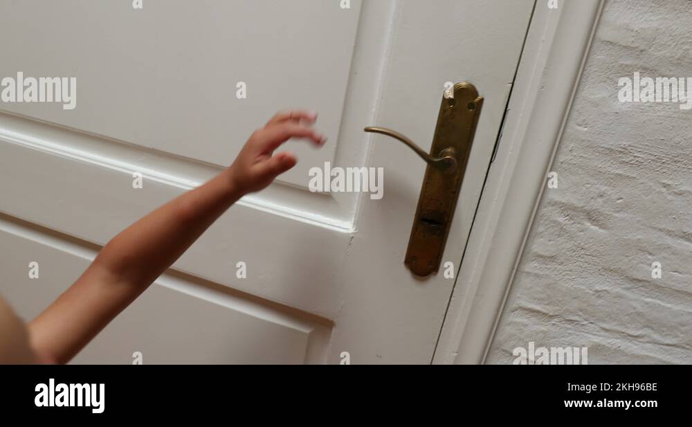 Toddler boy reaching door knob and opening front door and leaving house ...