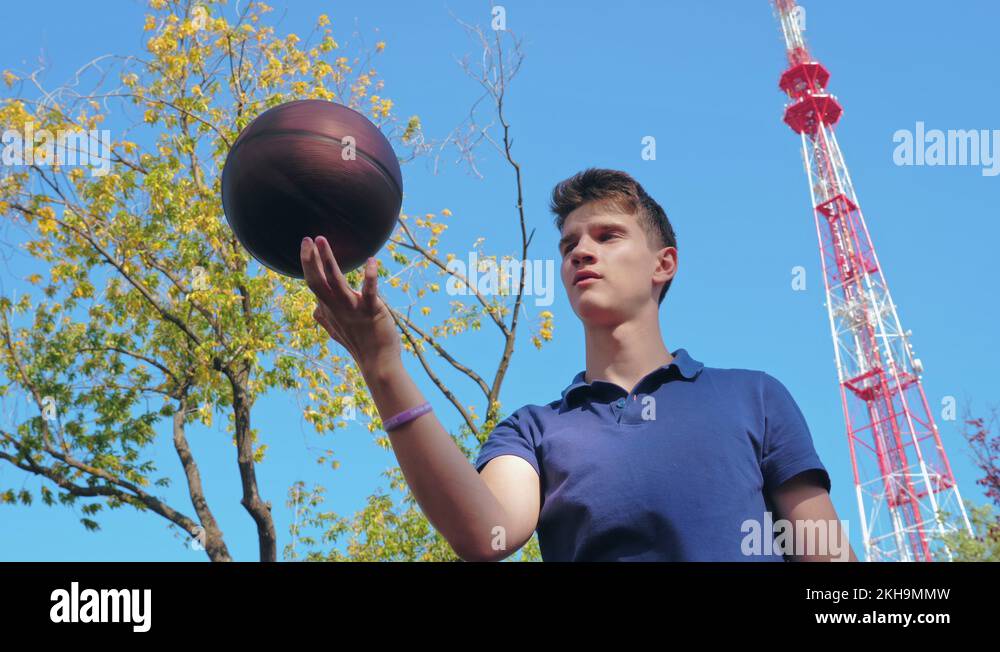 A young teenage man spins the ball on his finger while on the ...
