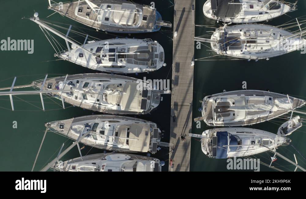 Low altitude aerial top down view of a marina pier and many docked ...