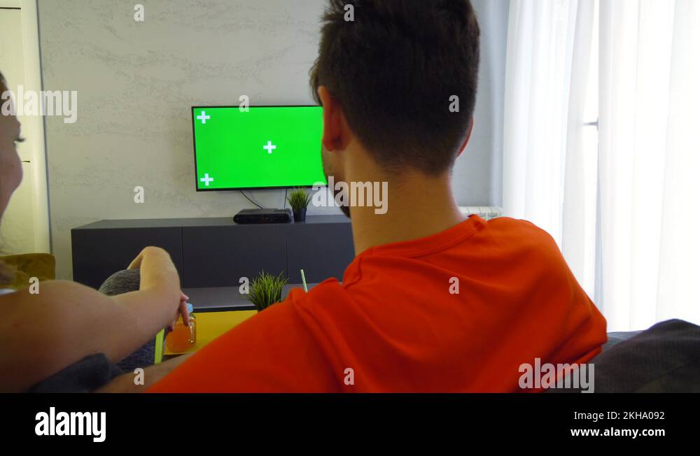 Couple in living room with green screen tv. Girl hugging boy Stock ...