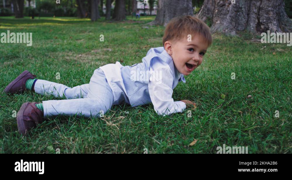 Closeup funny smiling large cute little boy running and hiding beside ...