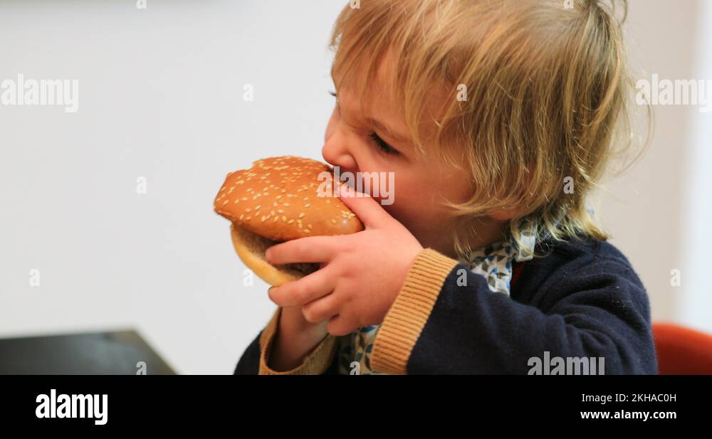Toddler boy eating burger, baby eating hamburger for the first time2 ...