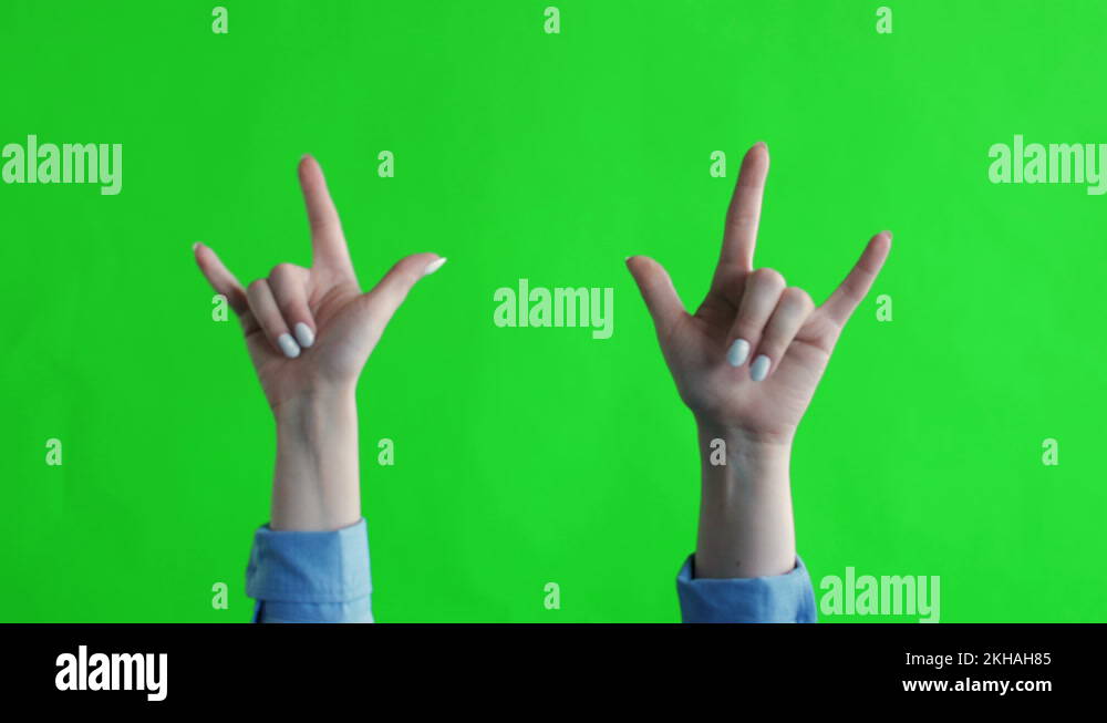 Sign of the horns with fingers on green screen. Simbol of heavy metal ...