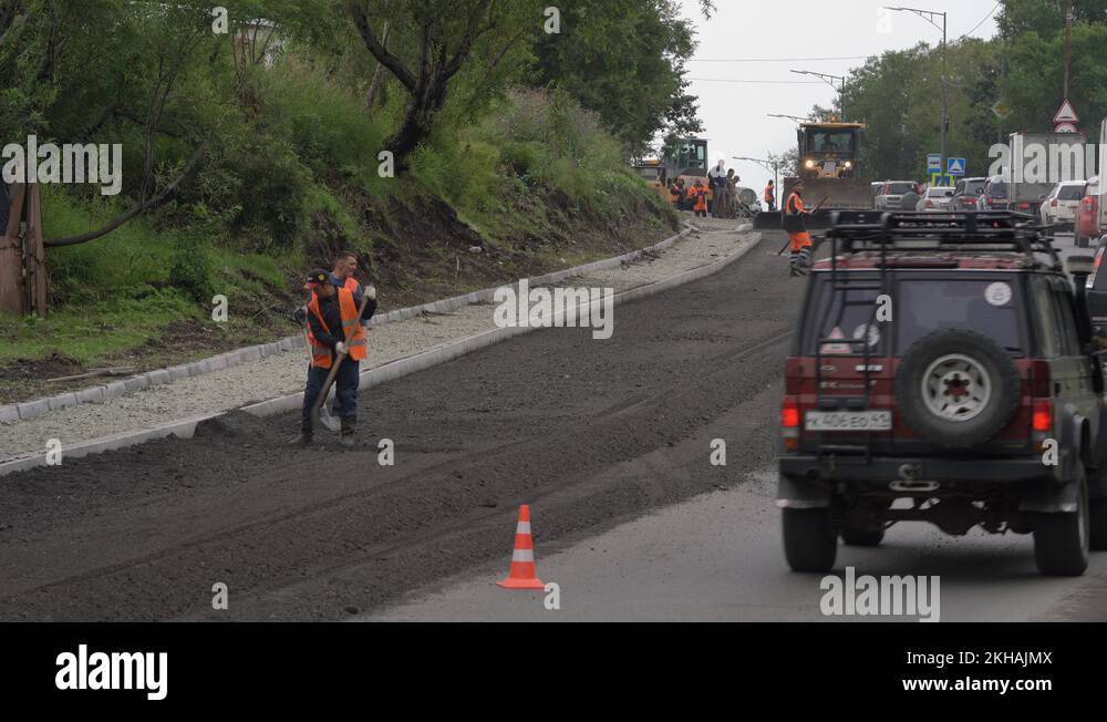 Road construction workers laying asphalt, road repairing, asphalt ...