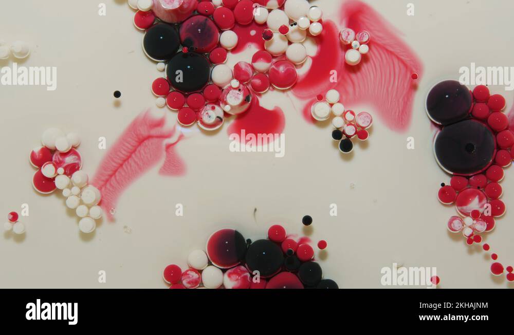 Red, white and black bursting and dissolving onto a white background ...