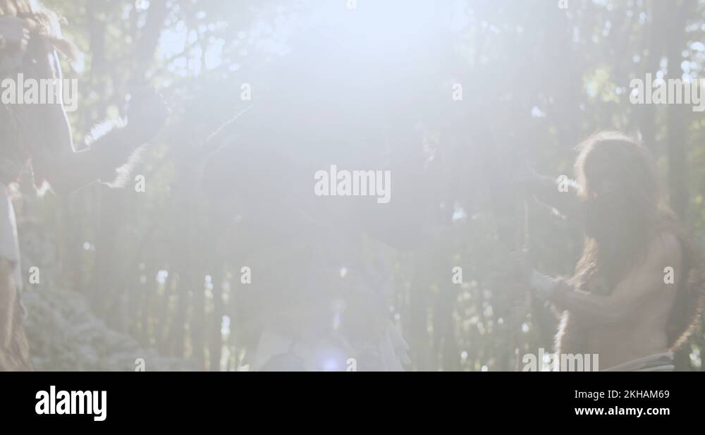 At sunlight tribe of cavemen neanderthals wearing animal skin holding ...