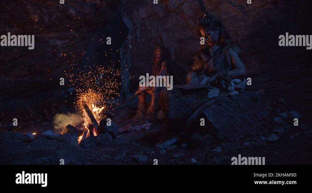 At night tribe cavemen neanderthals wearing animal skin woman use ...