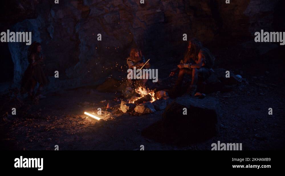 Wild cavemen neanderthals wearing animal skin discovering tablet ...