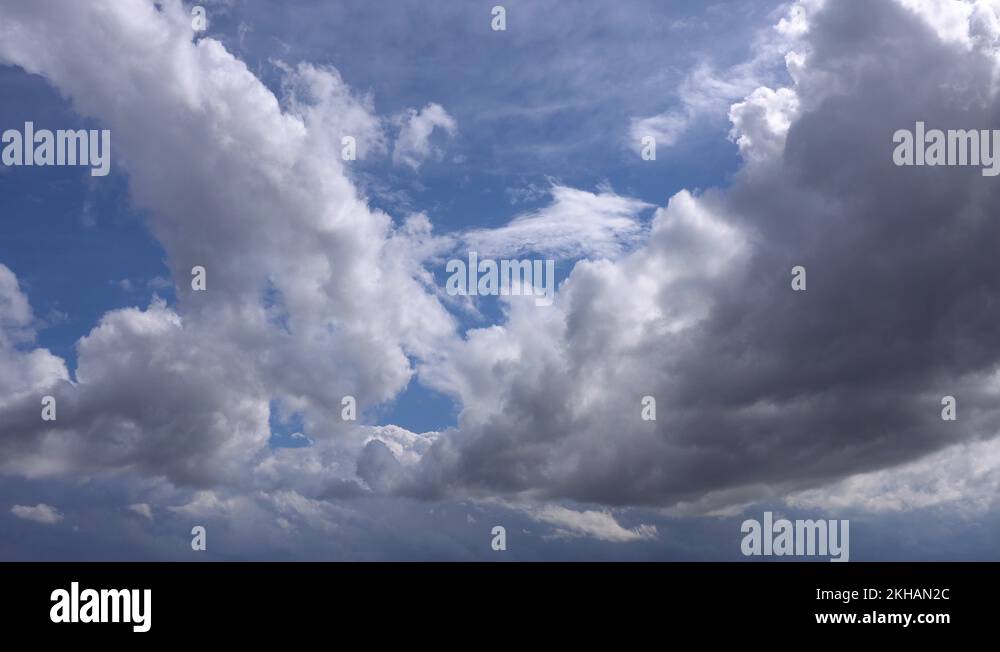 A view from the air on a layer of slow, fluffy white clouds with blue ...