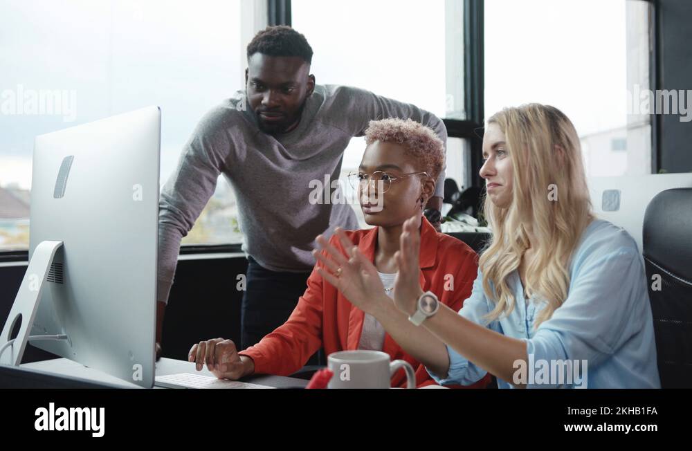 Team of ambitious multi-race office people working by desktop computer ...