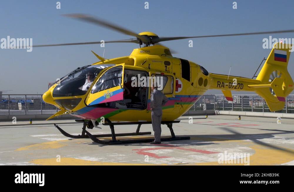 EC135 medical helicopter on roof hospital building with rotating blades ...