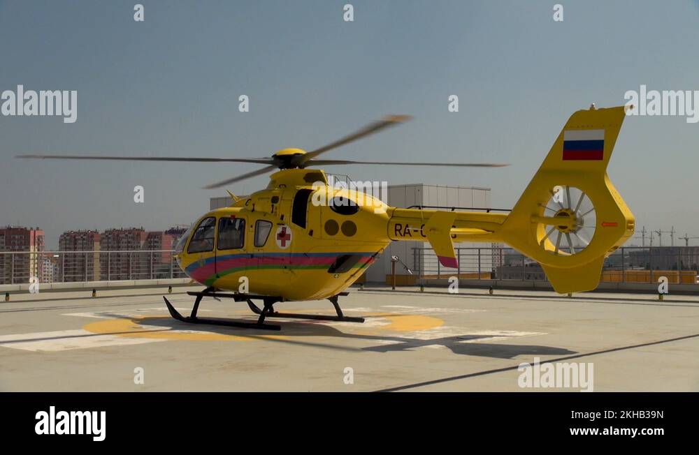 EC135 medical helicopter on roof hospital building with rotating blades ...