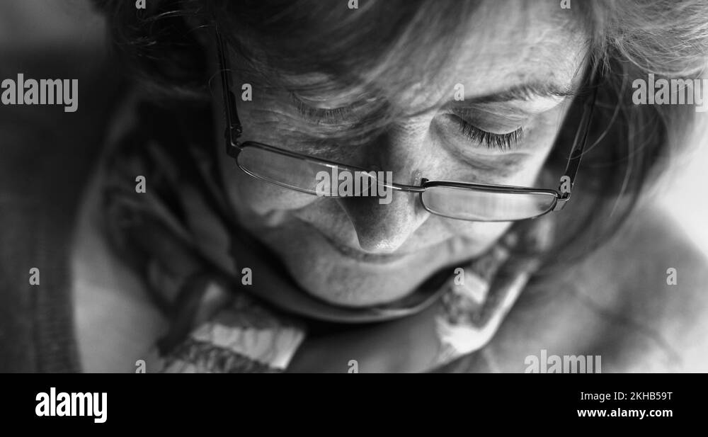 Candid black and white Older woman scratching face and hand while ...