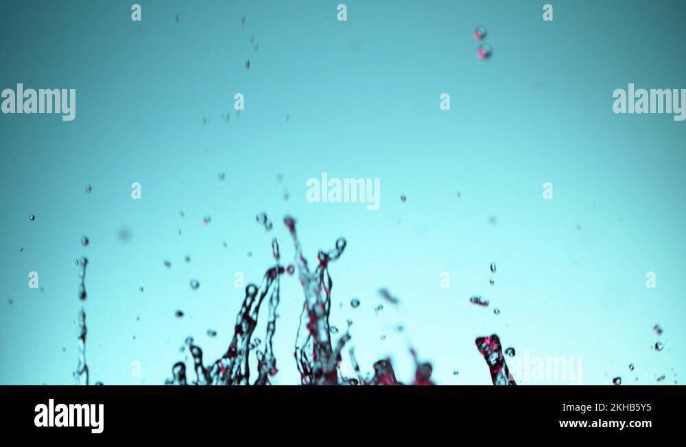 Super slow motion of exploding water splashes on soft blue background ...