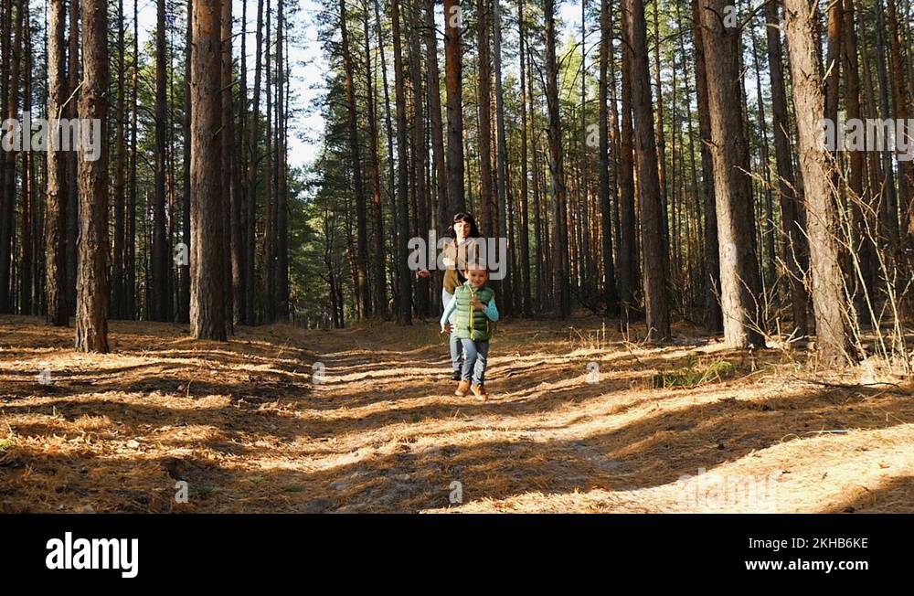 A young mother plays with her son, catching up with him. The child runs ...