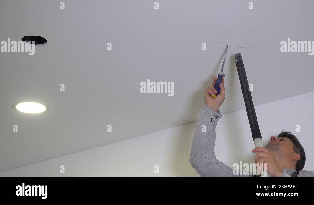 man saw round hole in plasterboard ceiling. Led light panel ...