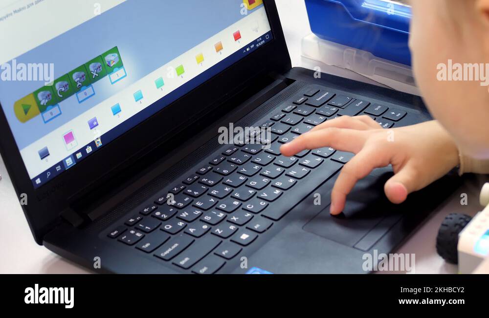 close-up, a child working on a laptop, typing on a keyboard. school and ...