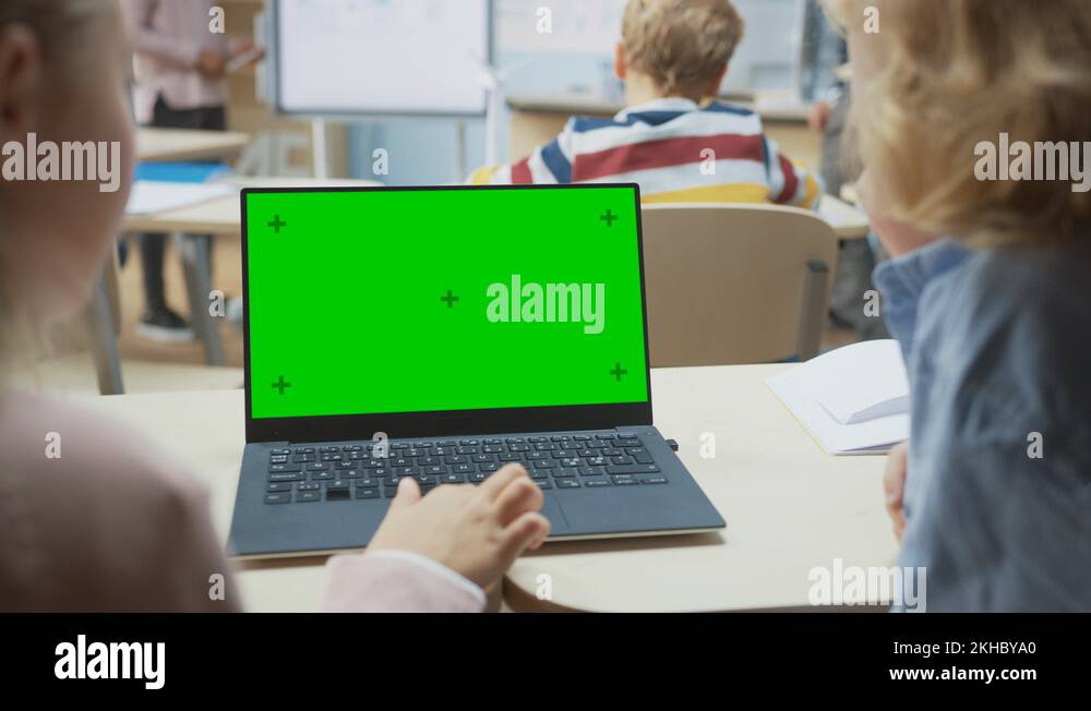 Elementary School Classroom: Two Kids Using Green Mock-up Screen Laptop ...