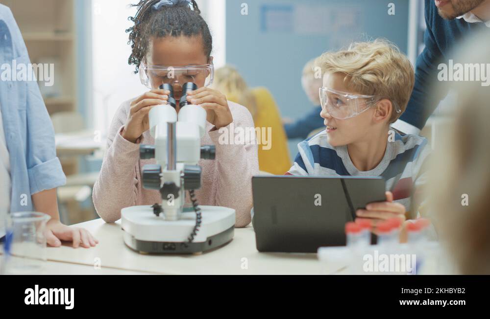 Elementary School Science Classroom: Cute Little Girl Looks Under ...