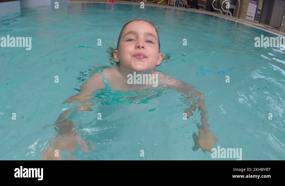 Girl swims for the first time herself. Happy little girl learning to ...