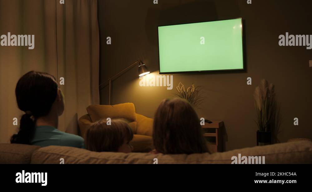 Family Sitting Together Sofa In Their Living Room Night Watching TV ...