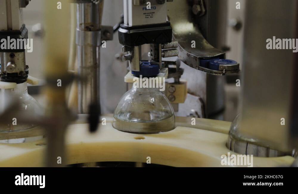 Pouring medicine on an assembly line into glass bottles for injection ...