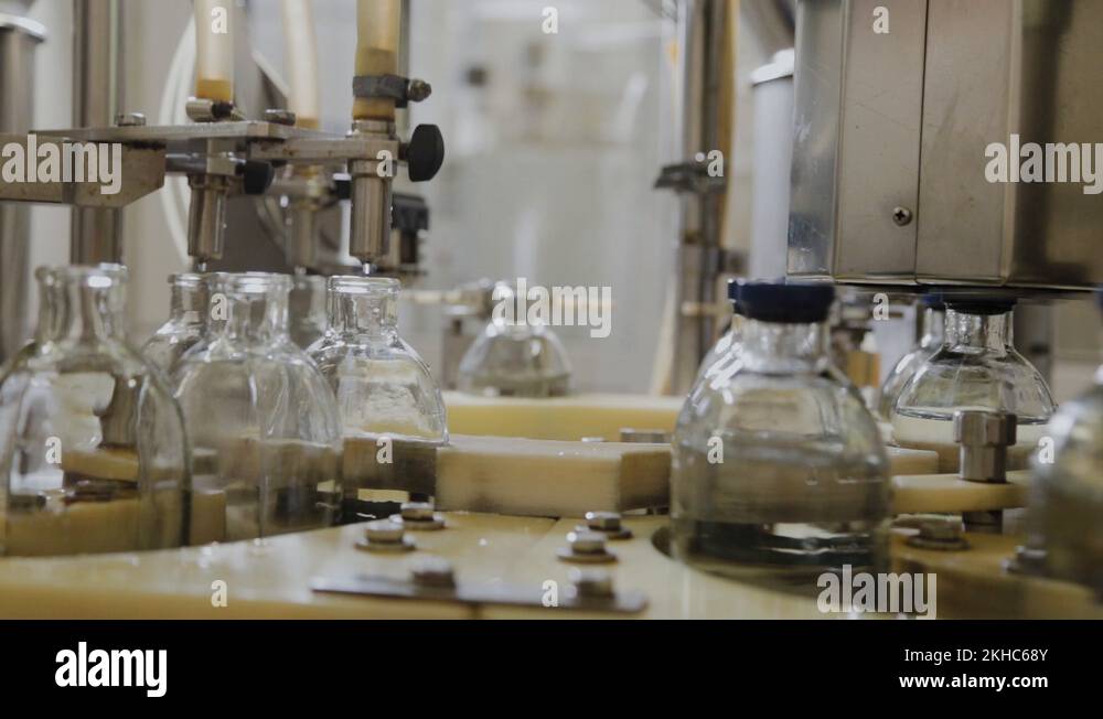 Pouring medicine on an assembly line into glass bottles for injection ...