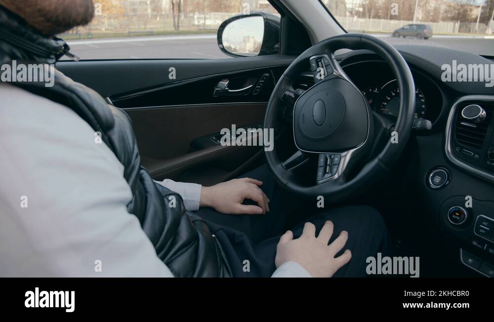 Male driver is sitting in an automatically moving car. Self-driving ...