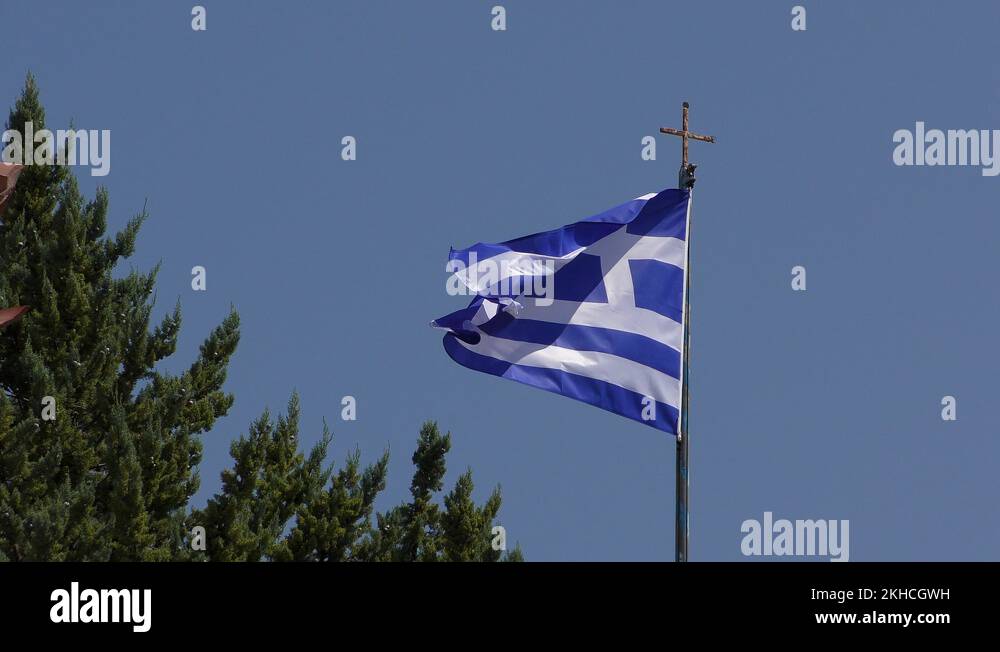 Orthodox cross on the flagpole and flag of Greece on a background of a ...