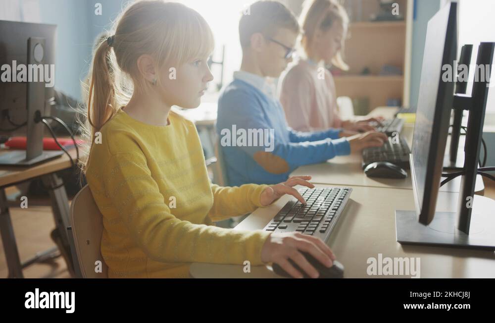 Elementary School Computer Science Classroom: Cute Little Girl Uses PC ...