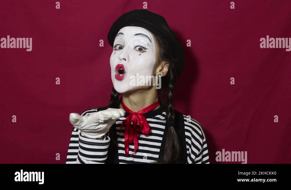 Beautiful girl mime sends air kiss and smiles looking at the camera ...